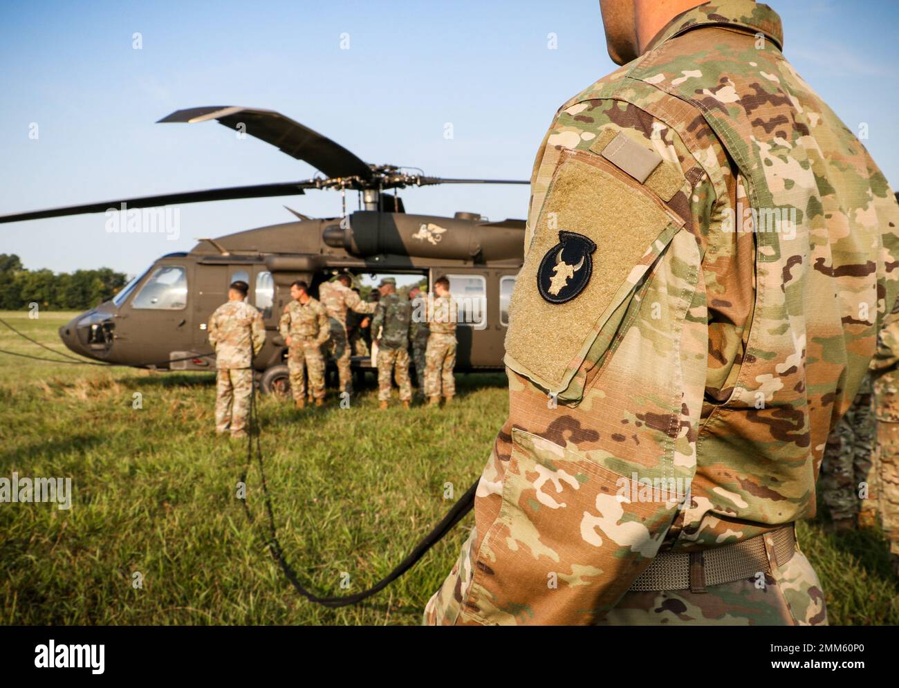 An Iowa Army National Guard Soldier holds on to a cable as Soldiers and ...
