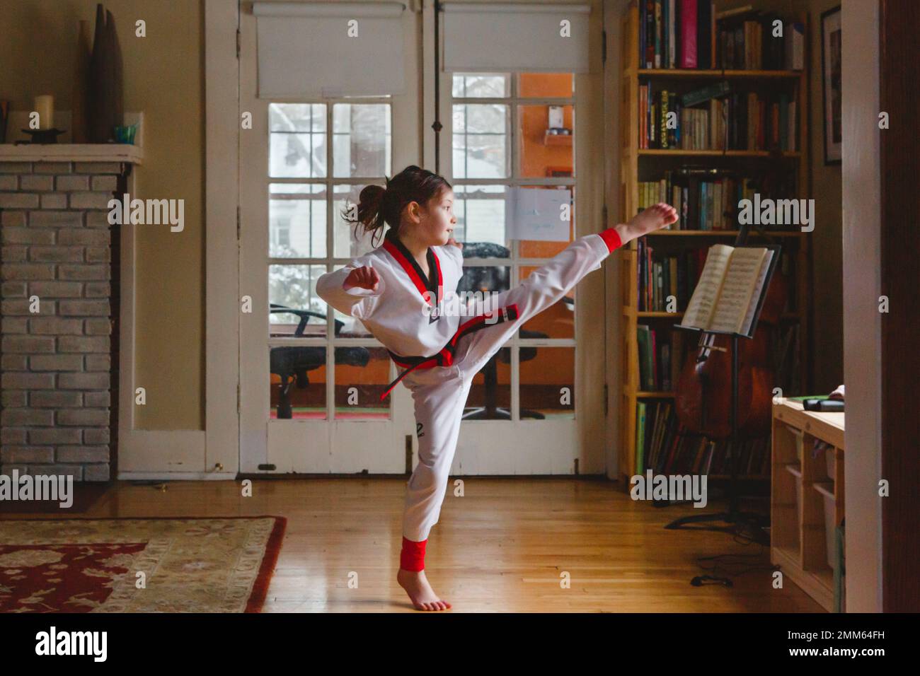 A young girl does Taekwondo kick in uniform at home Stock Photo - Alamy