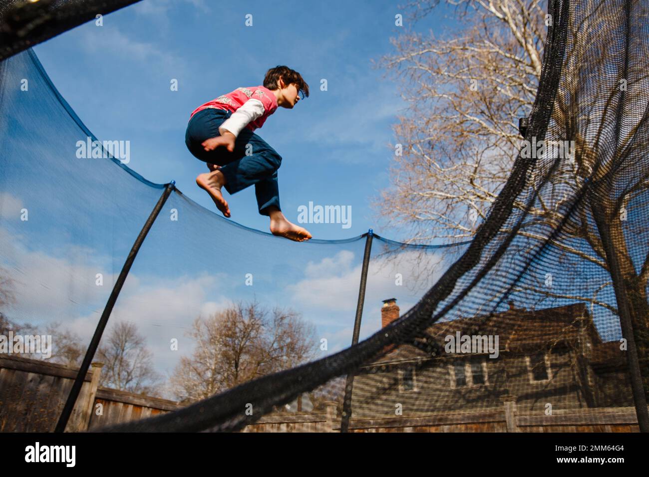An athletic boy jumps high in trampoline against blue sky Stock Photo ...