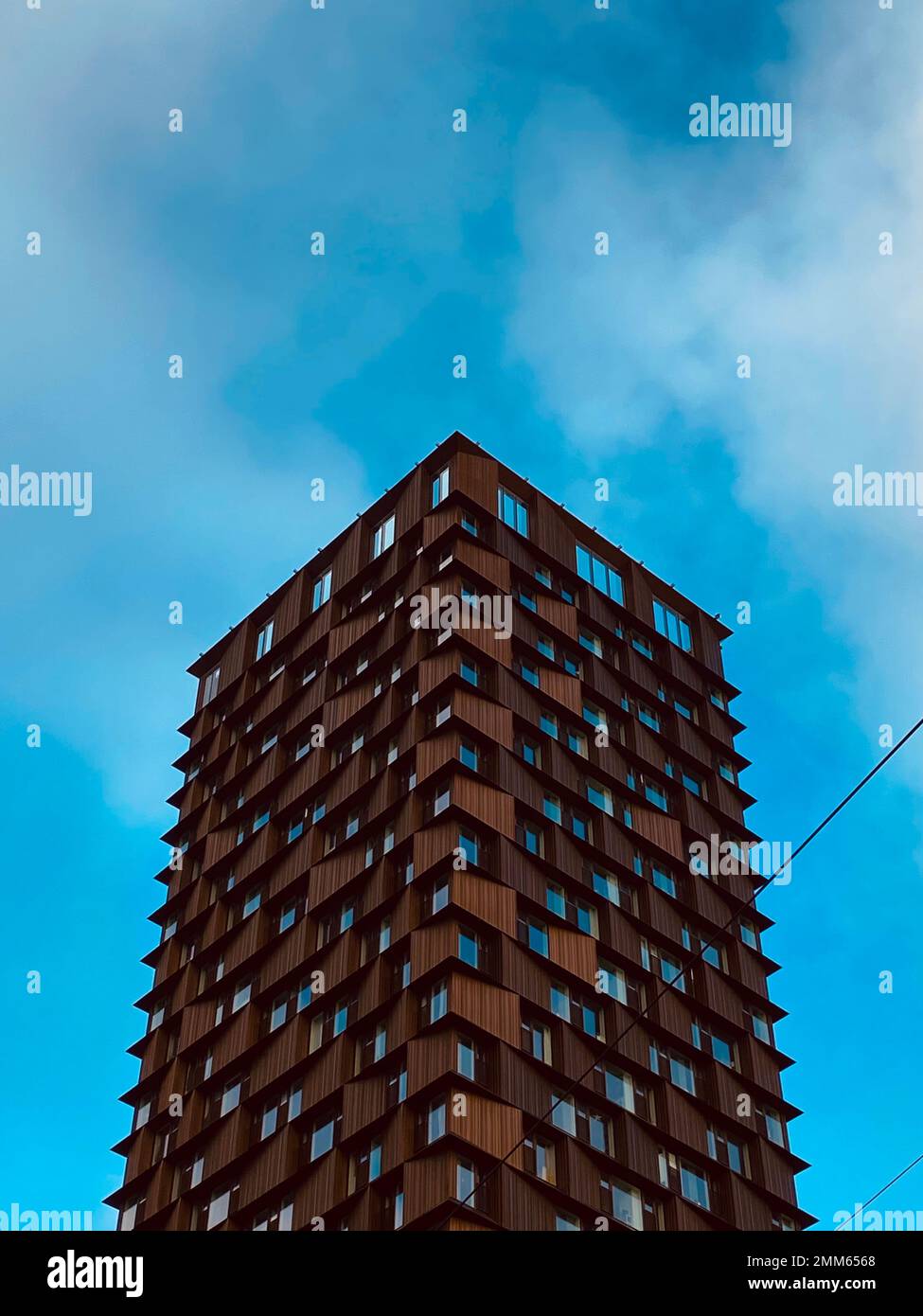 building with many windows seen from below against blue sky Stock Photo ...