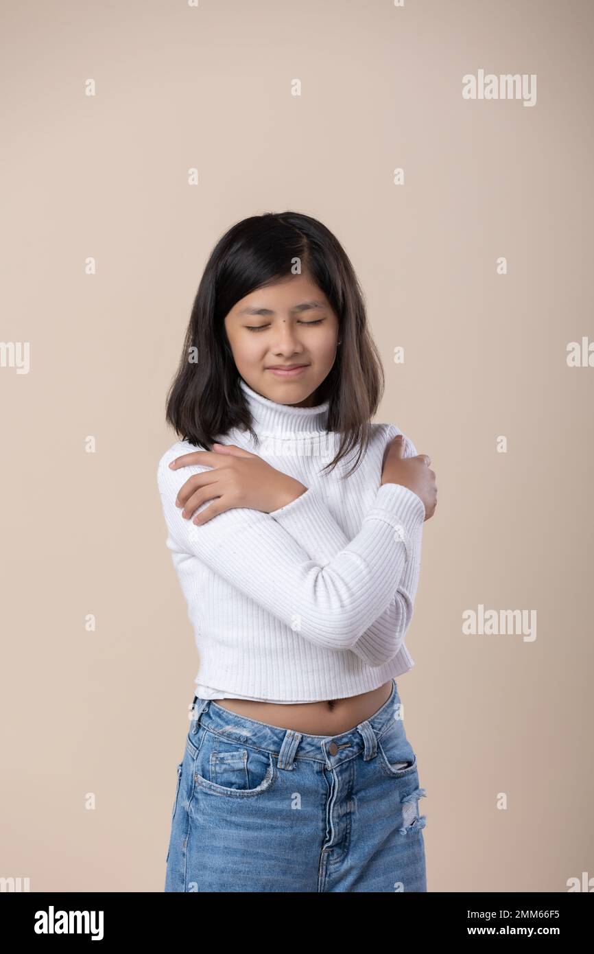 Mexican girl hugging herself, self love concept Stock Photo - Alamy