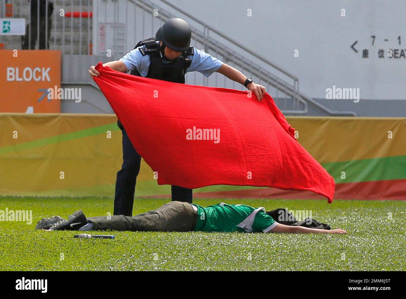 A police officer uses red cloth to cover a man who acts as a casualty ...