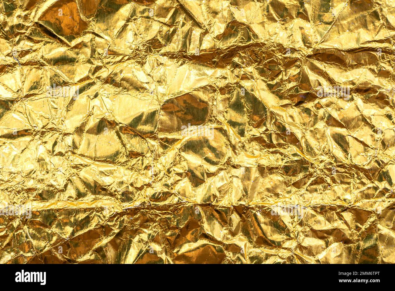 Luxurious golden foil texture. Crumpled yellow foil with scuffs and ...