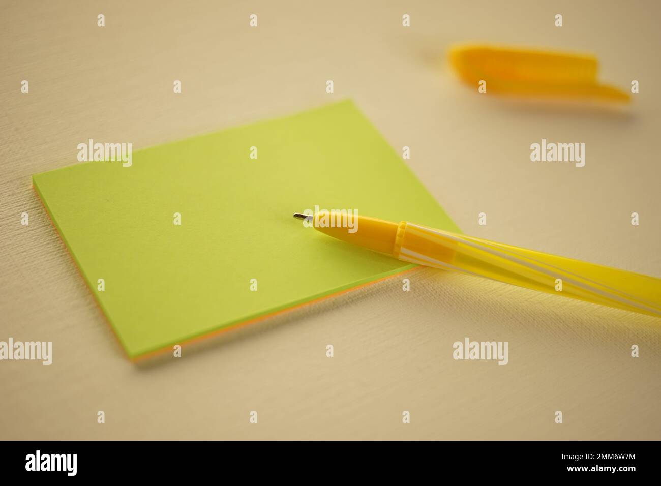 Yellow ballpoint pen with cap and green notes on beige paper Stock ...
