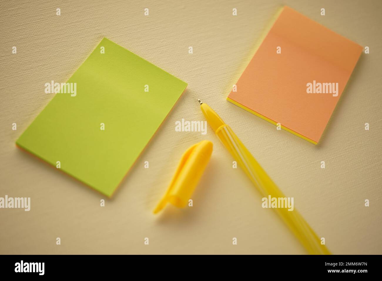 Yellow ballpoint pen and notes on beige paper Stock Photo - Alamy