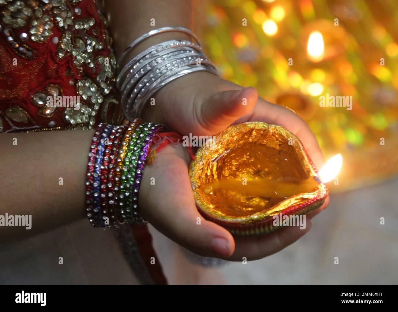 A Pakistani Hindu girl holds an oil lamp to celebrate Diwali, the ...