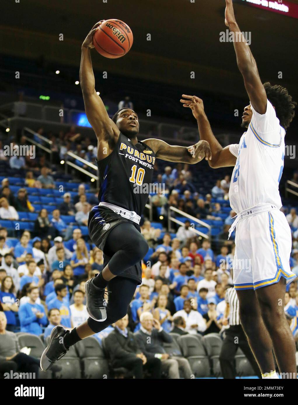 Fort Wayne guard Dee Montgomery, left, goes to the hoop as UCLA guard ...