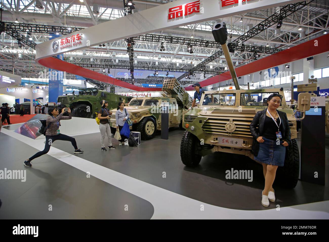 Visitors pose for photographers near the howitzers of the booth of Dong ...