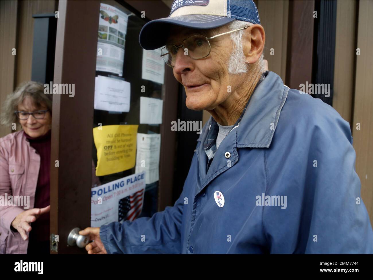 A man holds the door at a crowded polling station in Pennsylvania's 7th ...