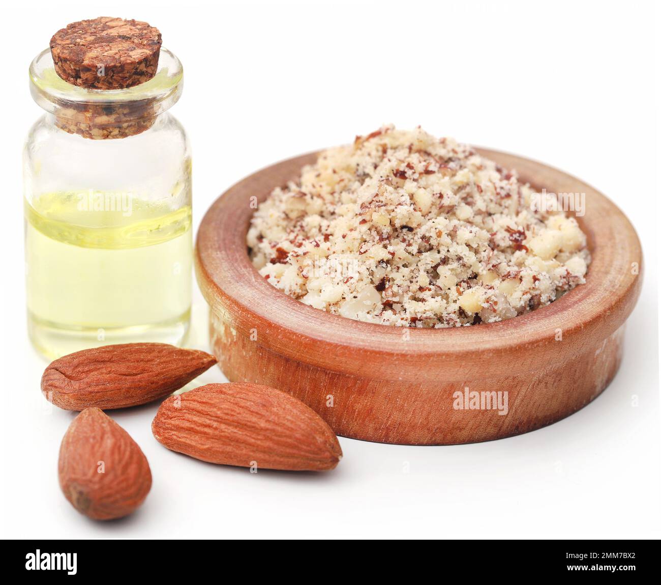 Crushed with peeled almond with oil in a bottle over white background ...