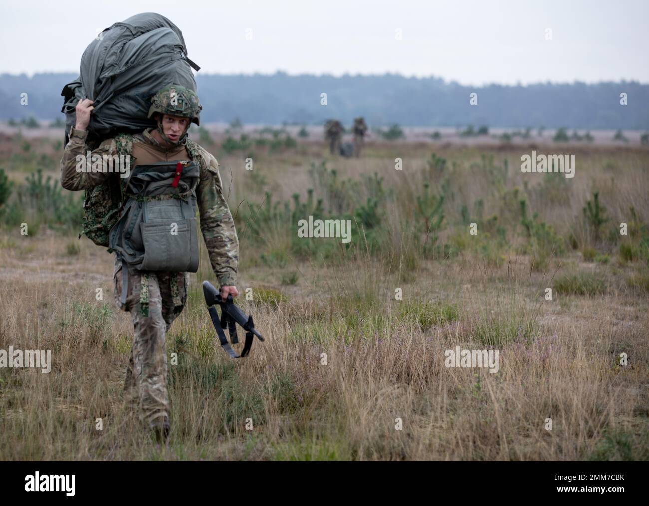 A Dutch Paratrooper walks off the Drop Zone with his assigned parachute ...