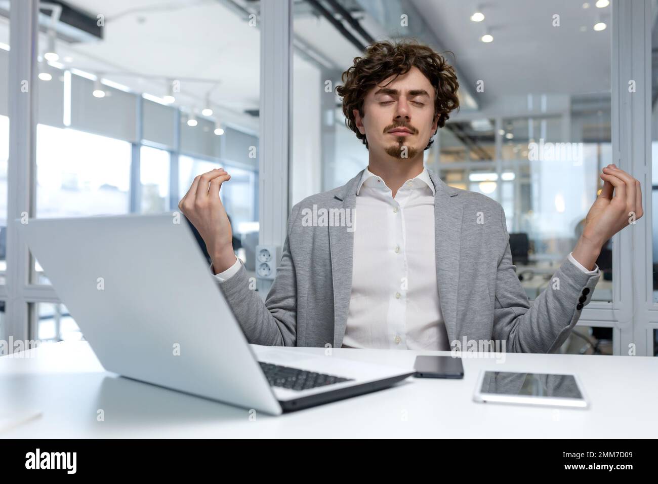 Hispanic businessman in bright white office relaxing at workplace, man ...