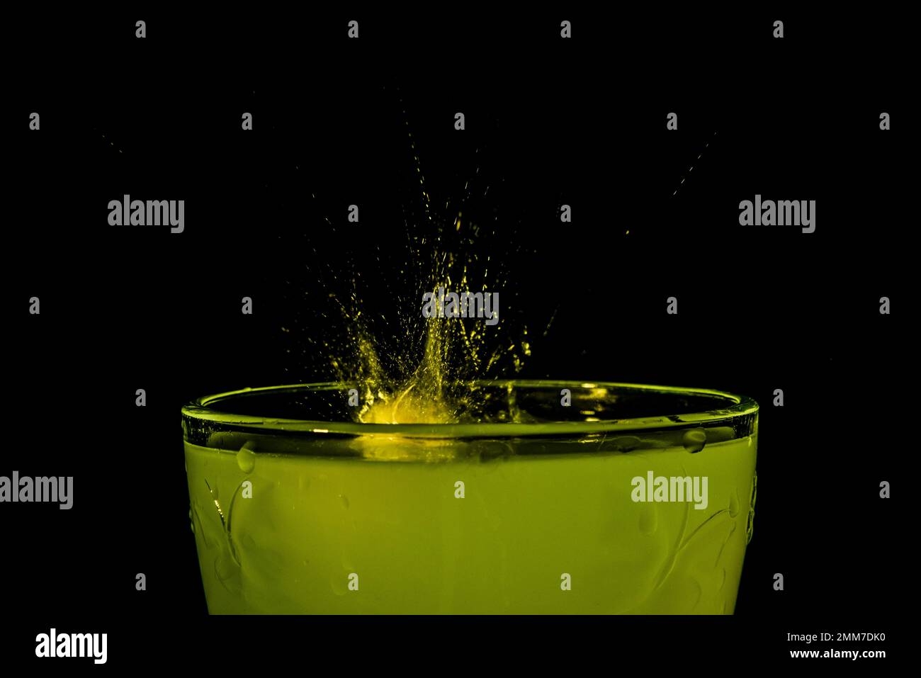 Color fresh blue milk drops into white milk in cup with dark black ...