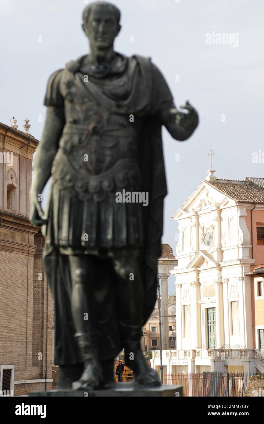 A construction worker is framed by a statue of Roman Emperor Julius ...