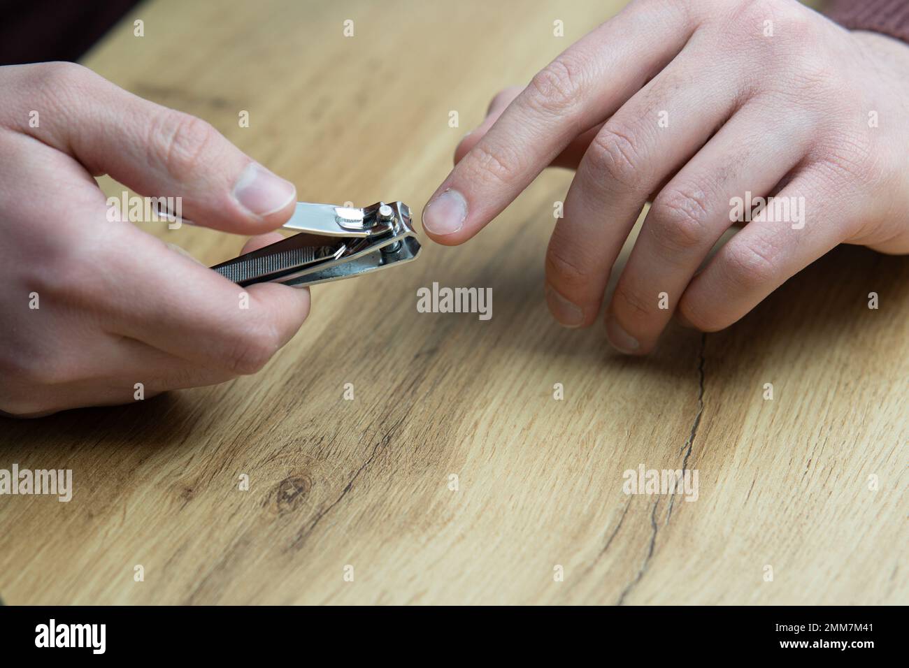 Close up of male hands cutting fingernails. Young handsome man clipping ...