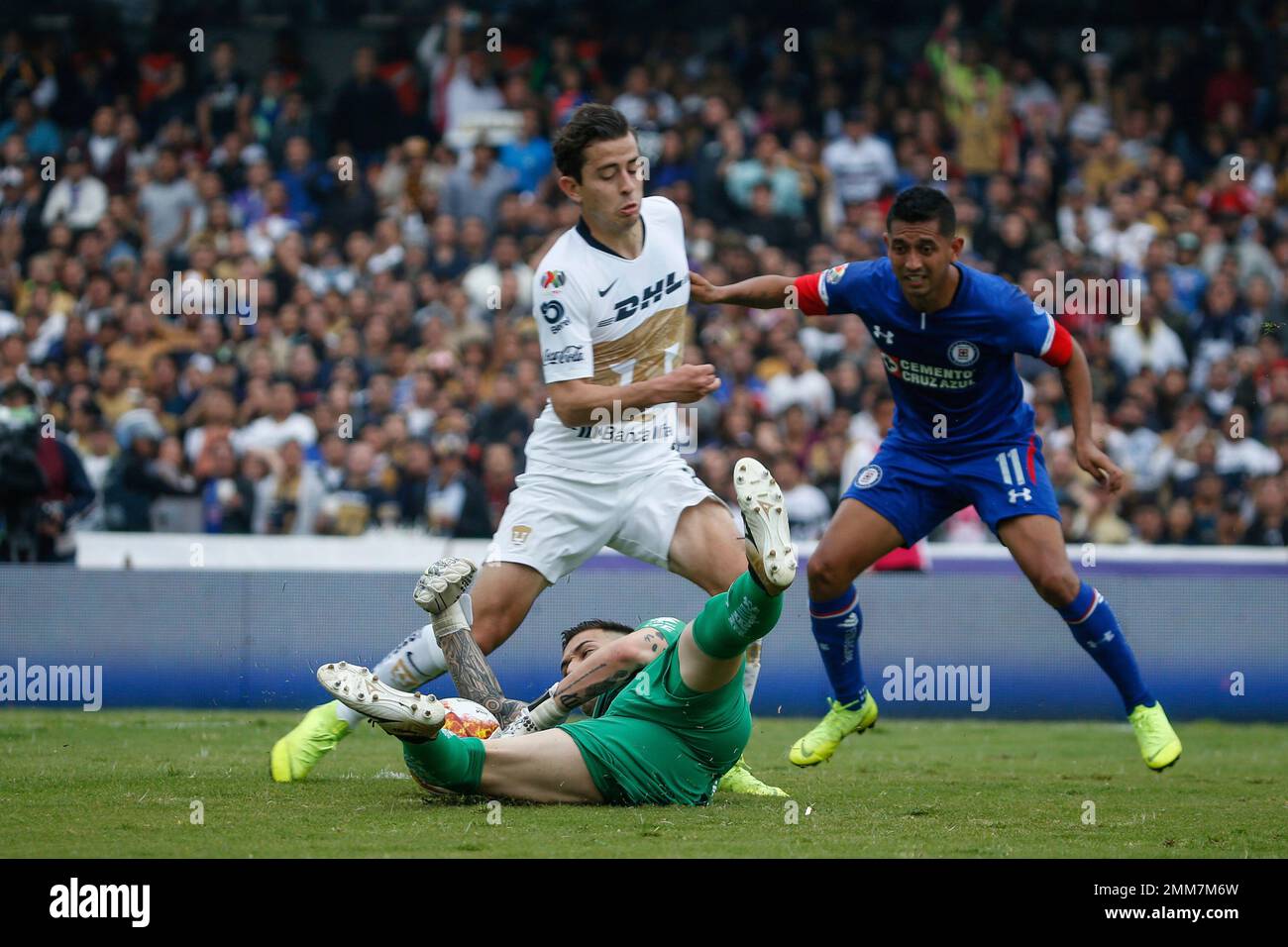 Puma's goalkeeper Alfredo Saldivar, bottom, blocks the ball from ...