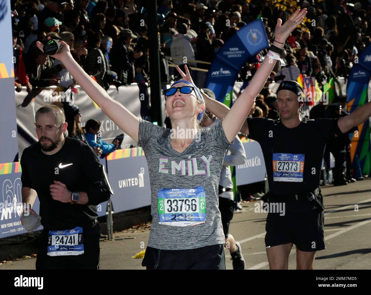 Emily Sharp reacts as she crosses the finish line of the New York City ...