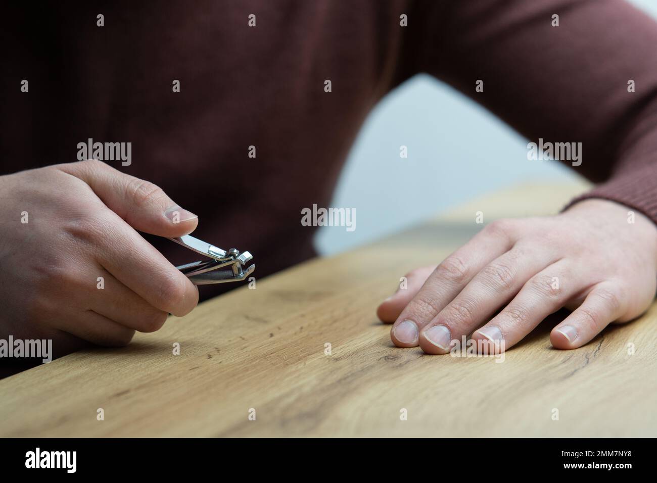 Close up of male hands cutting fingernails. Young handsome man clipping ...