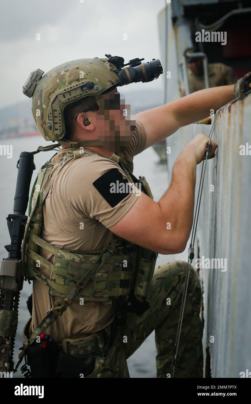 A U.S. Sailor assigned to a Navy SEAL Team, climbs up a ladder during ...