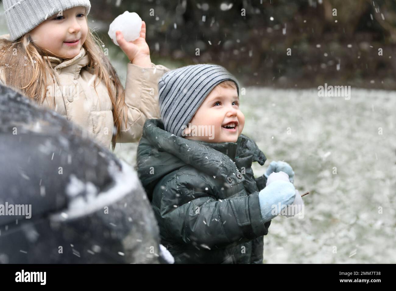 The brother and sister playing snowballs outside Stock Photo - Alamy