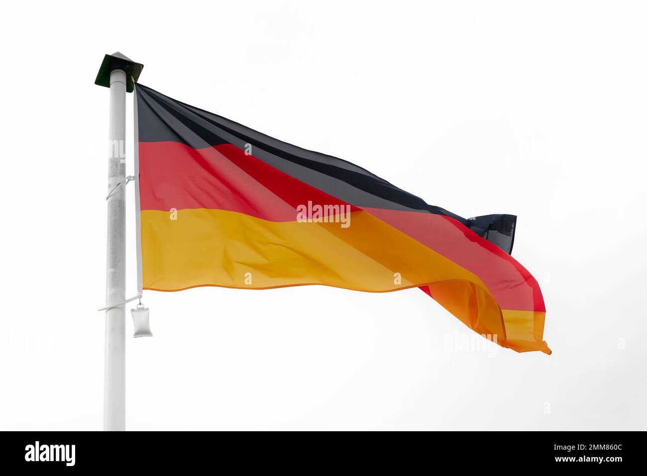 German flag waving in the wind on a flagpole with a white background ...