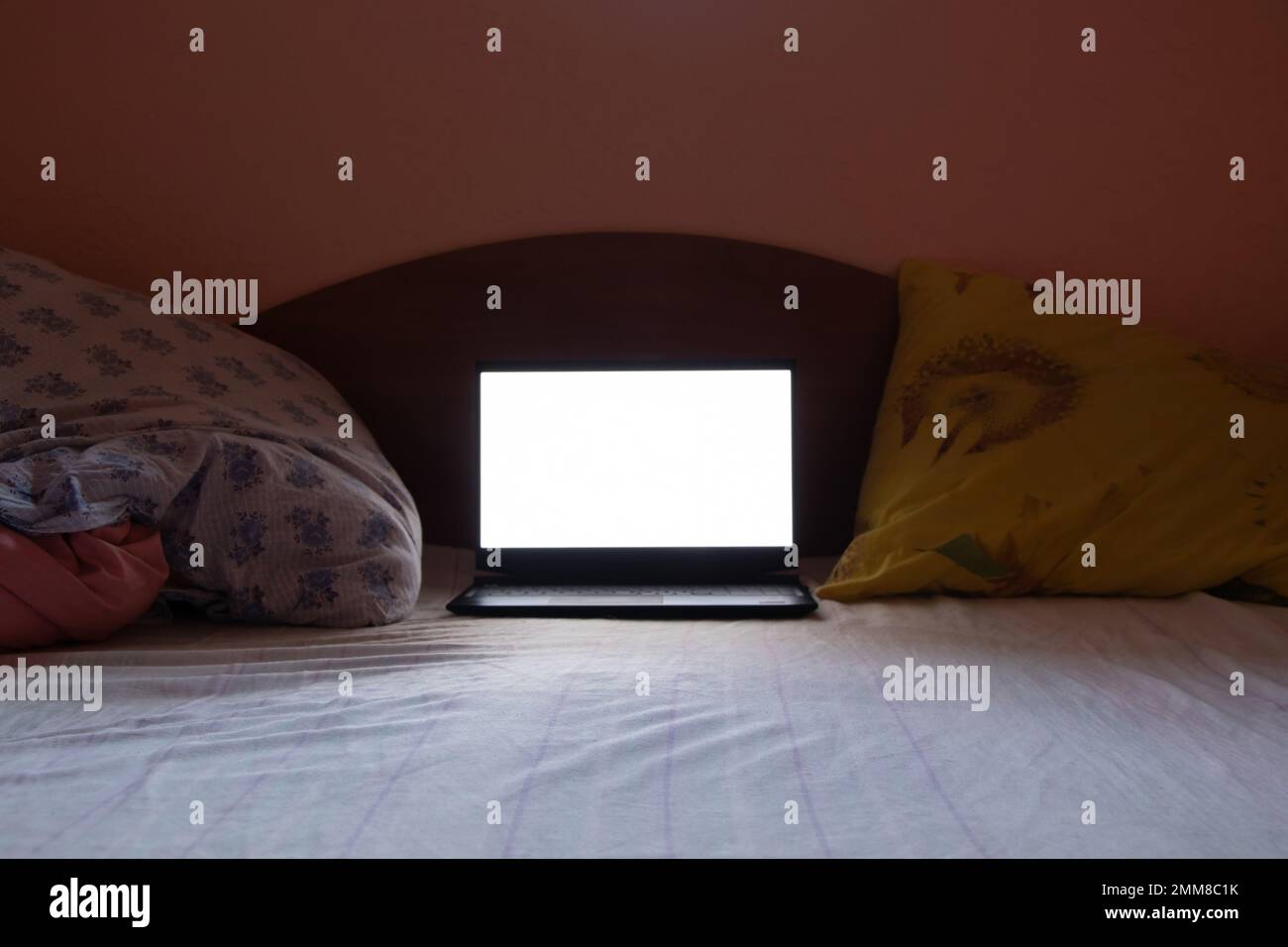 laptop with white screen stands on the bed in the bedroom at home ...