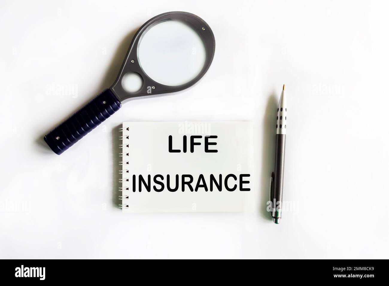 Life insurance word on notepad with magnifying glass and pen Stock ...
