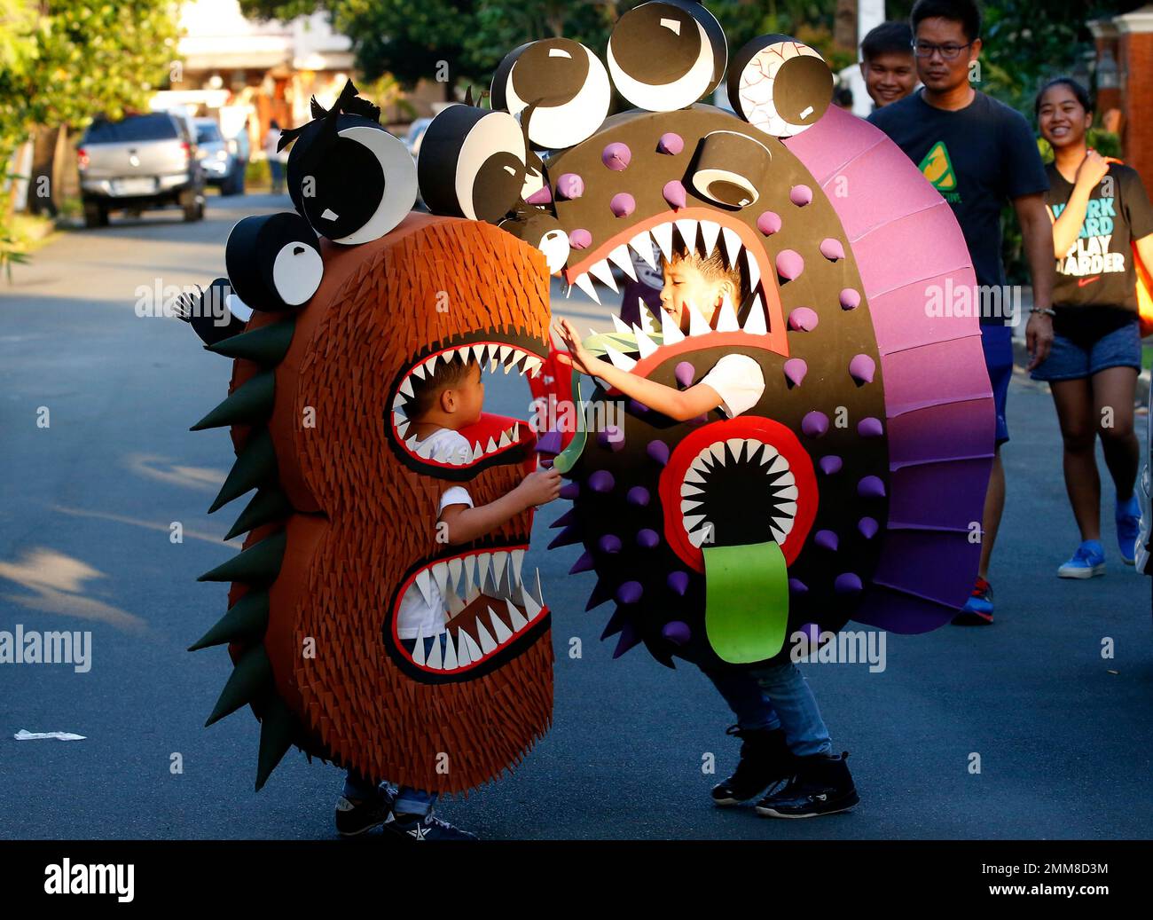Boys, dressed as monsters, play as they take a break from soliciting ...