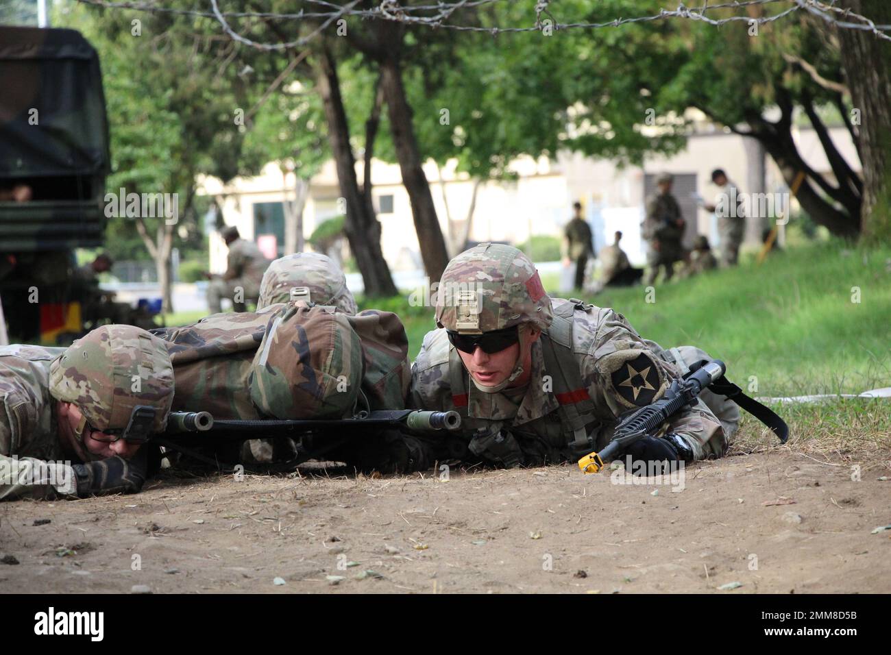 EFMB Candidate conducts the four-man litter carry under obstacles ...
