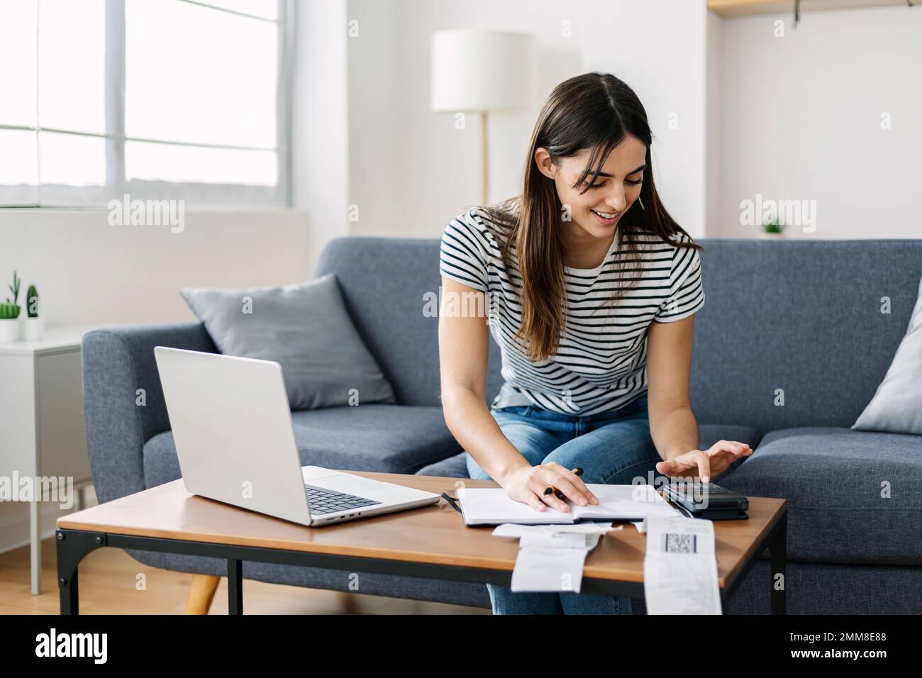 Young woman calculating household tax bills and expenses sitting on ...