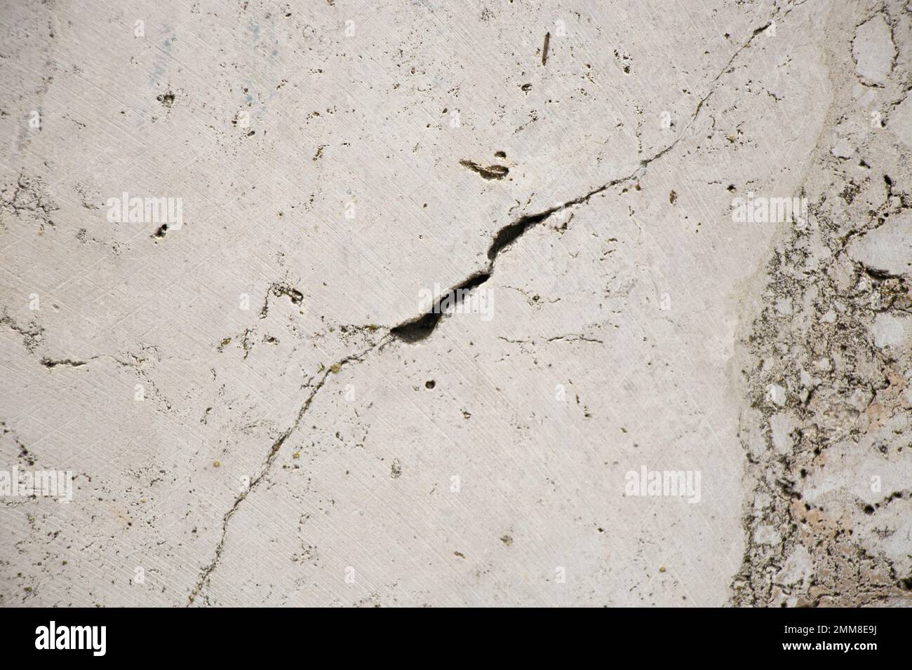 old marble stone light wall with cracks and holes as background, stone ...