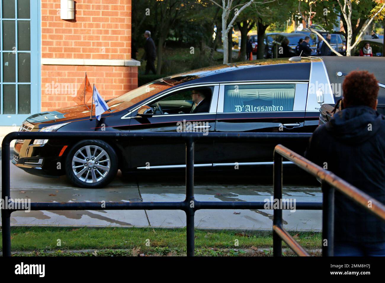 People hug as the hearse carrying the casket of Jerry Rabinowitz, one ...