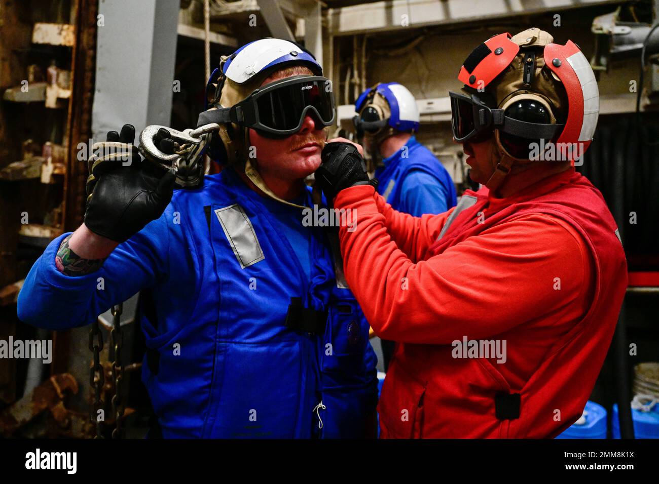 U.S. Navy Boatswain Mate 1st Class Steven Woolums, right, assists ...