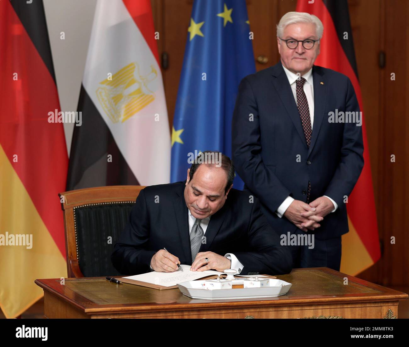 Egyptian President Abdel Fattah al-Sisi, left, signs the golden book at ...