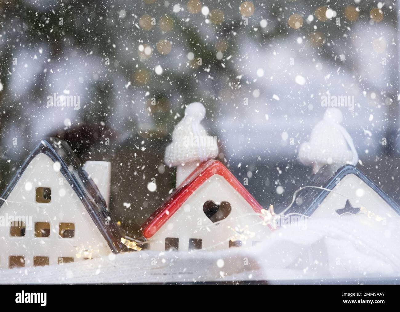 Cozy house is wrapped in a hat and scarf in a snowstorm -window sill ...