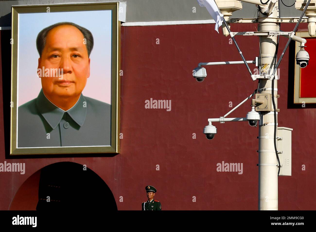 A paramilitary policeman stands guard near a portrait of the late ...