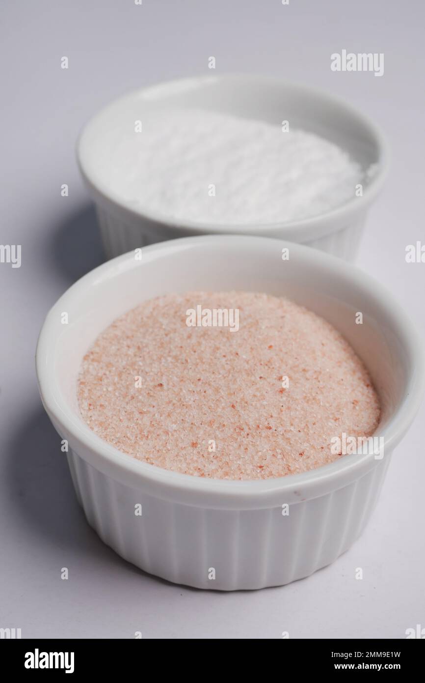 Raw whole dried pink Himalayan salt in a container on white Stock Photo ...