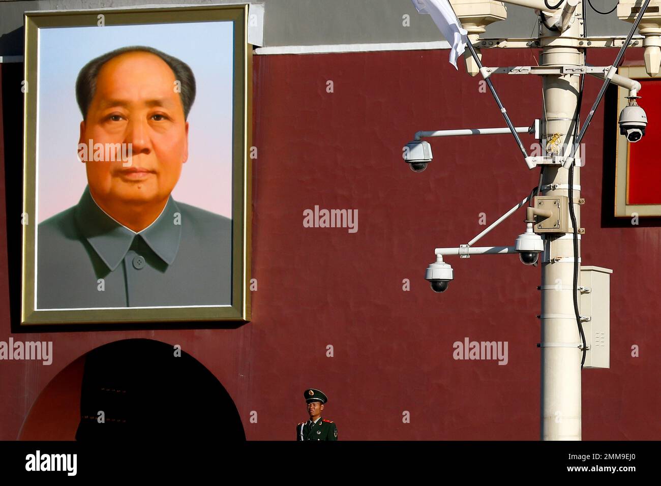 A Chinese paramilitary policeman stands guard near a portrait of the ...