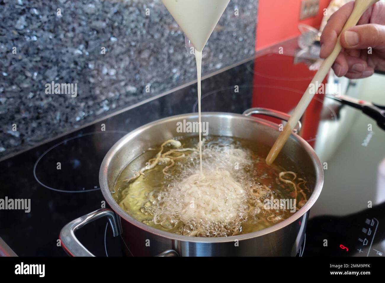 Swabian cuisine, preparation Striebele, put dough into hot fat, fat ...