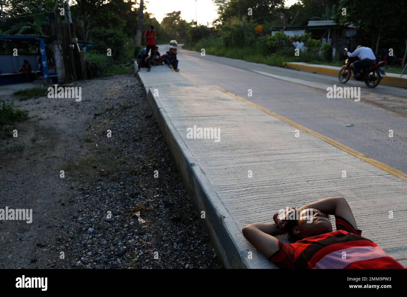 Liseth Lopez, 23, from Comayagua, Honduras, rests on a sidewalk as she ...