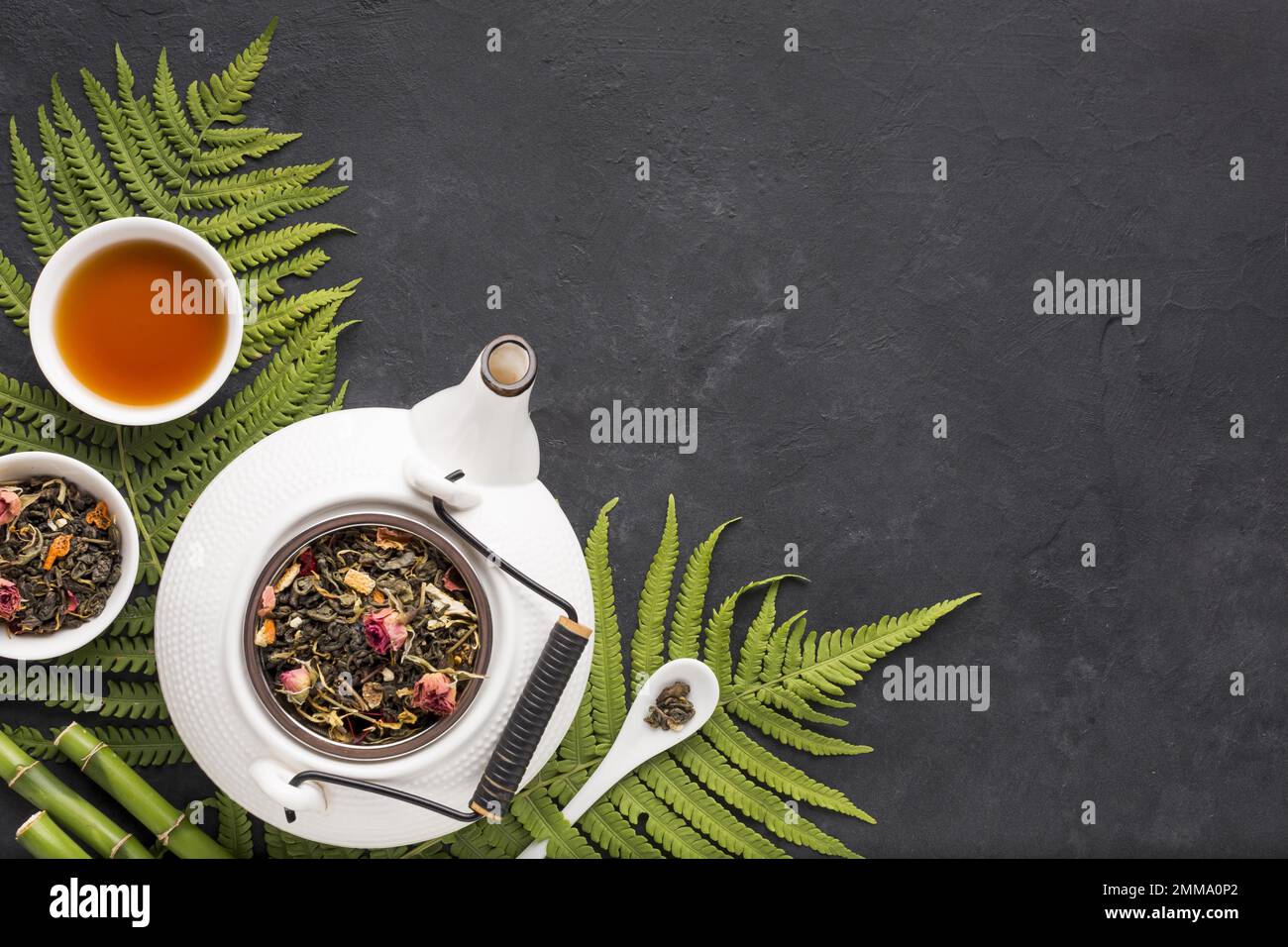 dried tea herb with fern leaves bamboo stick black textured backdrop ...