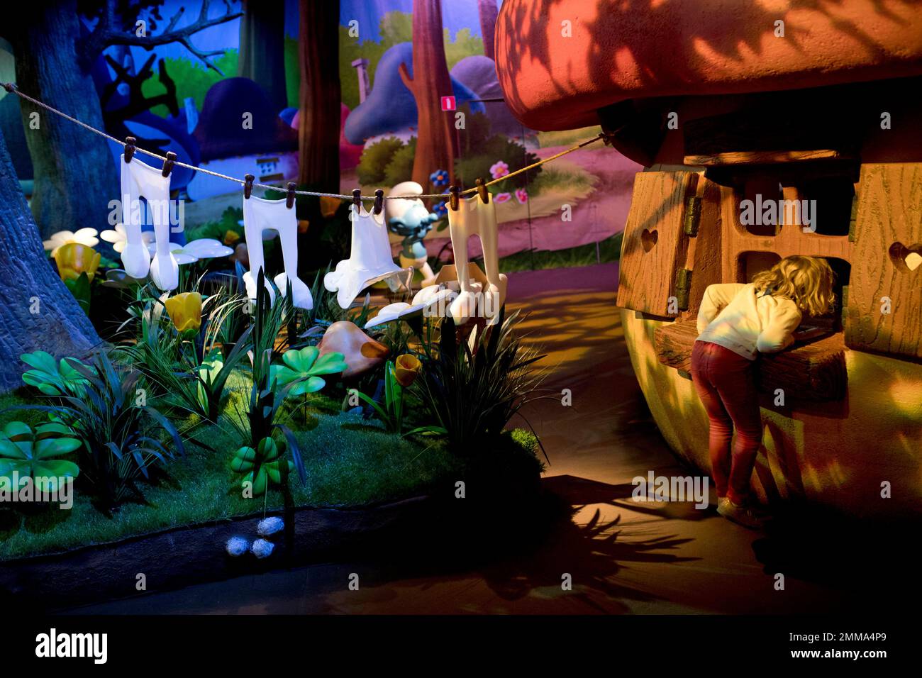A child peeks inside a Smurfs house during the Smurfs exhibition ...
