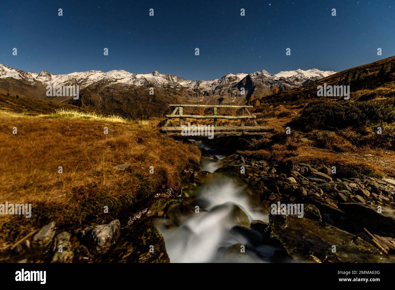 Mountain stream in moonlight with starry sky in autumnal landscape ...