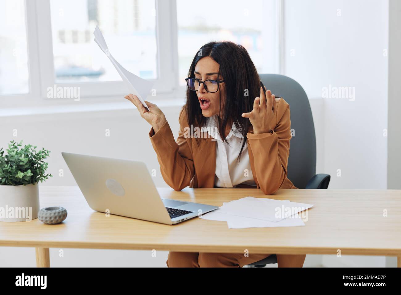 Business woman working in office at desk with laptop, anger and ...