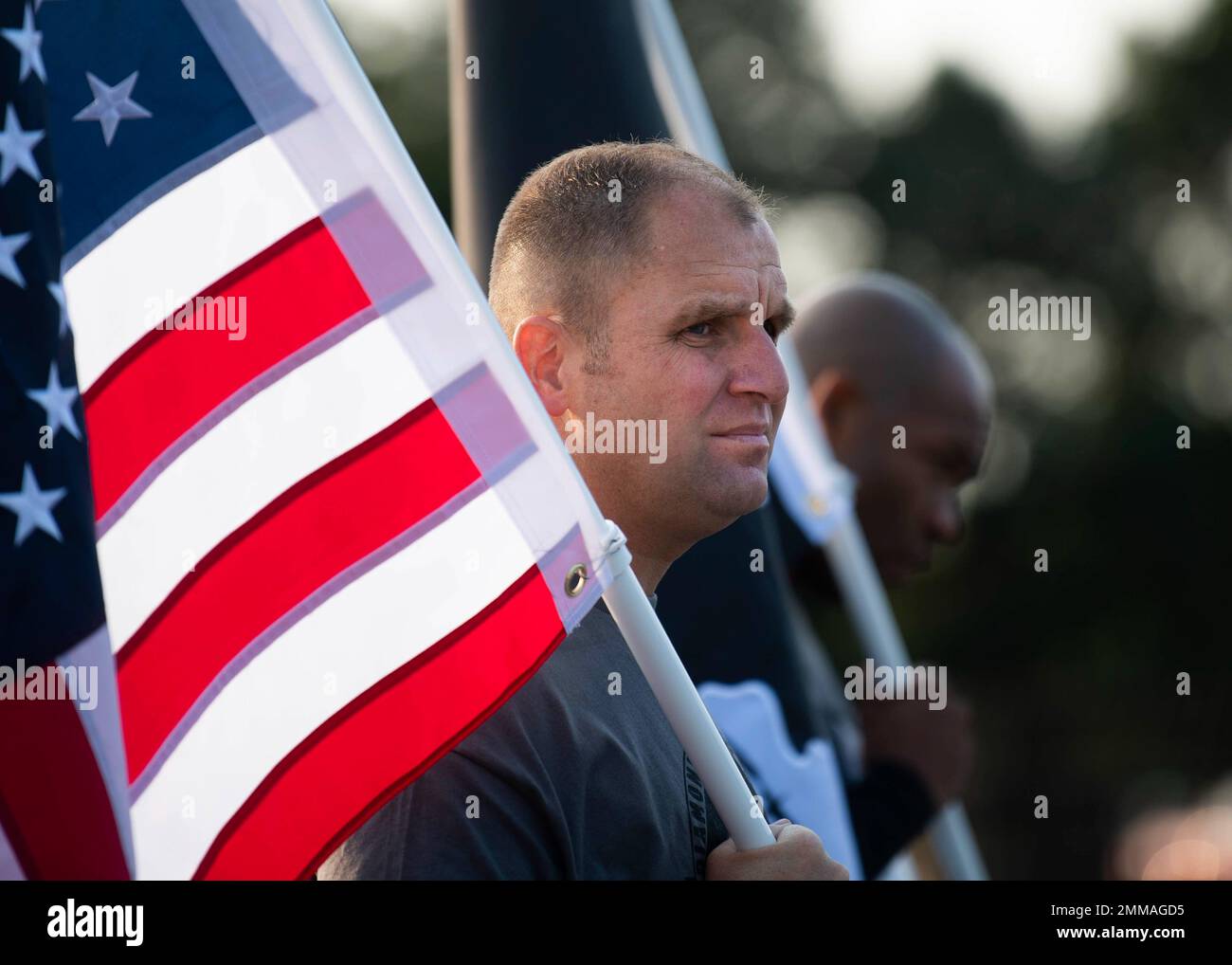 A member of Team Dover holds the U.S. flag while waiting to run in a ...