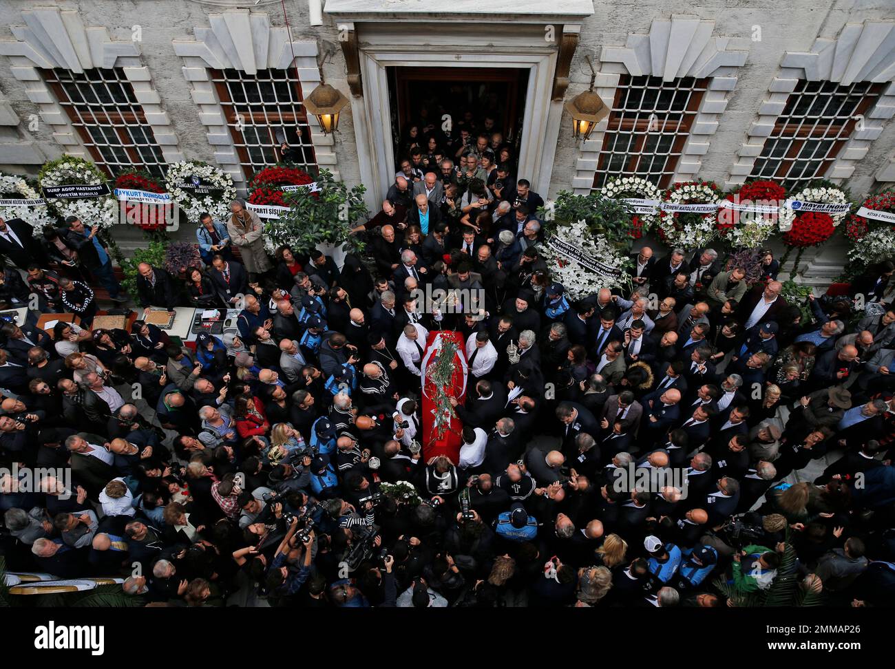 Mourners gather around the Turkish flag-draped coffin of acclaimed ...