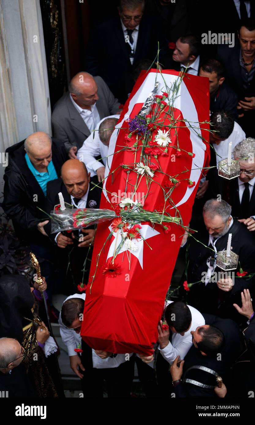 Mourners gather around the Turkish flag-draped coffin of acclaimed ...