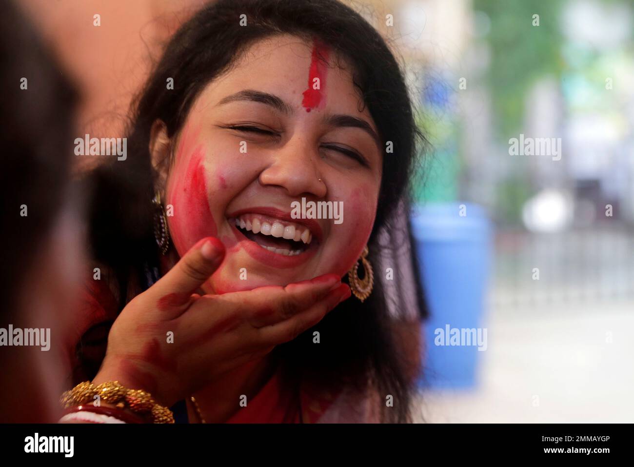 An Indian woman smears vermilion powder on another during Vijayadashmi ...