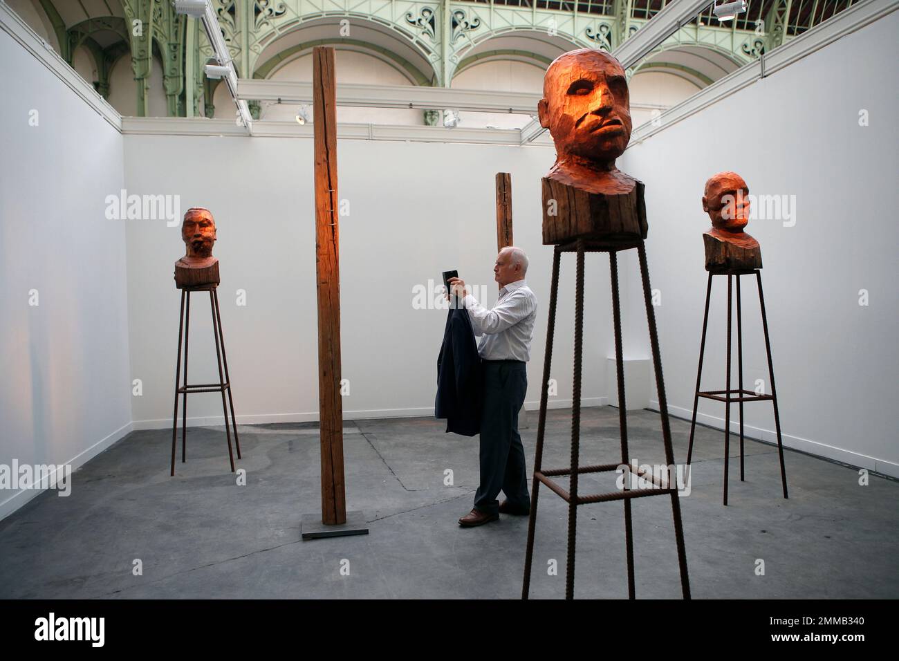 A man takes pictures with his phone of installations by artist Kader ...