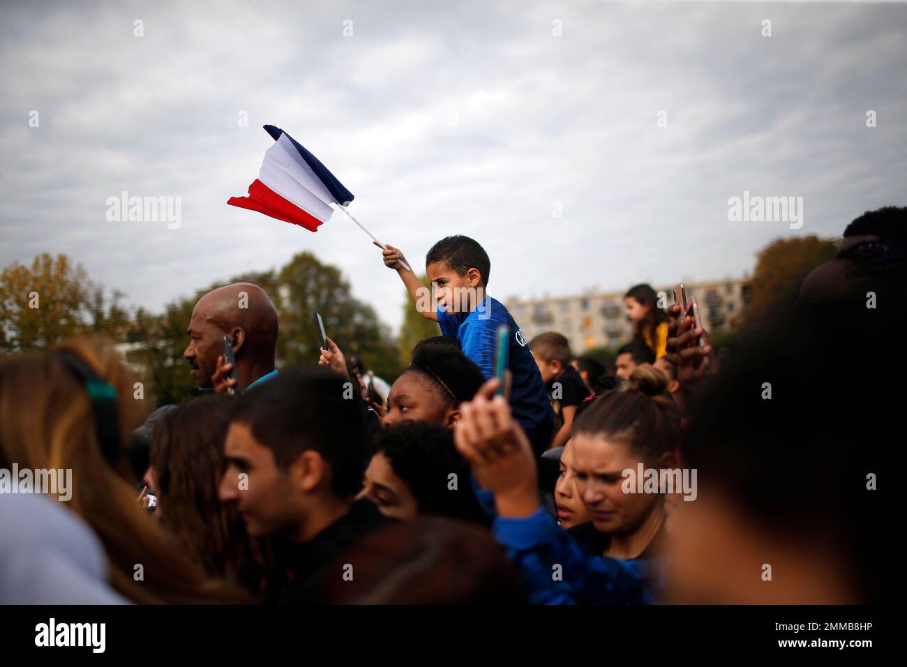 A child holds a French flag during a visit of France soccer team player ...